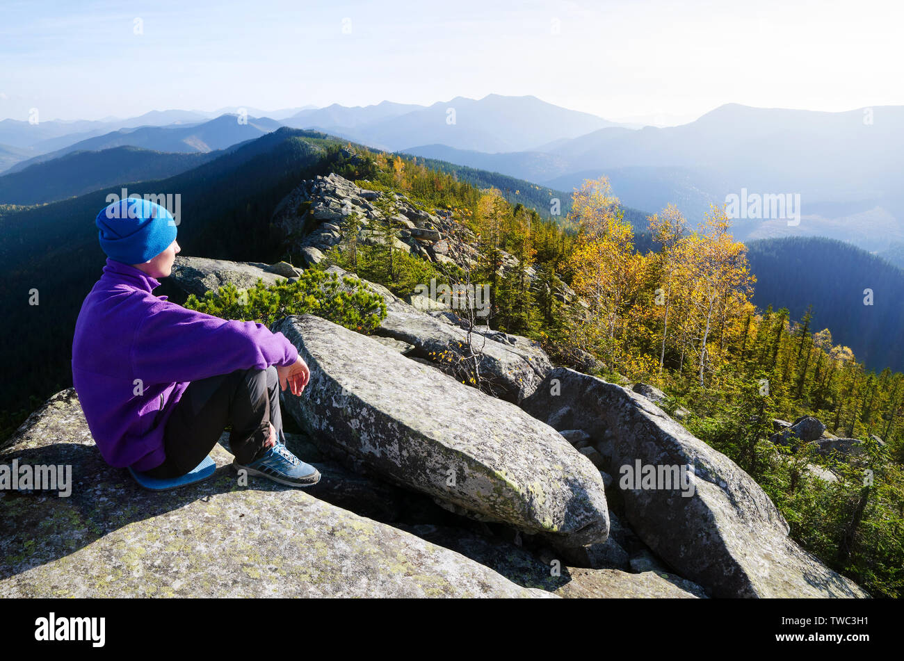 Guy on a mountain ridge contemplates nature. Autumn landscape on a ...