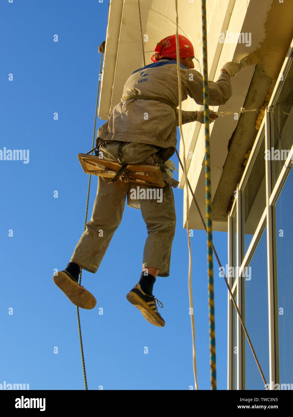 Alpinist worker doing high altitude job Stock Photo - Alamy