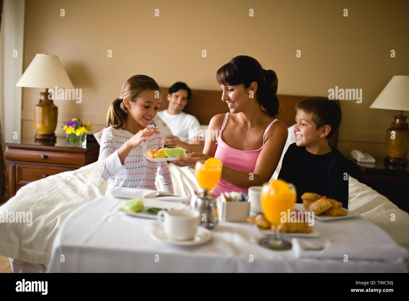 Family enjoying breakfast in bed in hotel room Stock Photo - Alamy