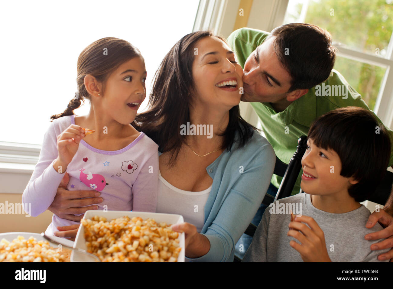 Happy family having fun eating at a dining table Stock Photo - Alamy