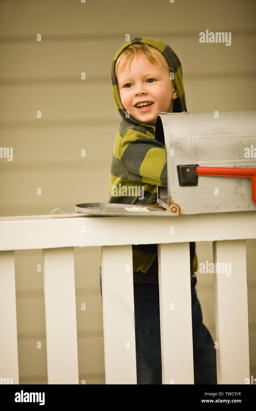 A young boy checking the letterbox Stock Photo - Alamy