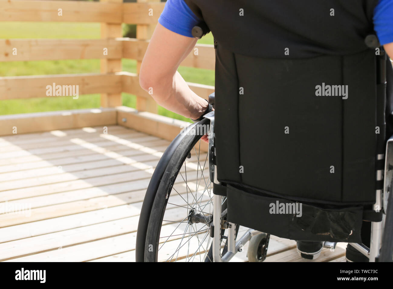 Disabled young man on a wheelchair holding and turning wheels with hand ...