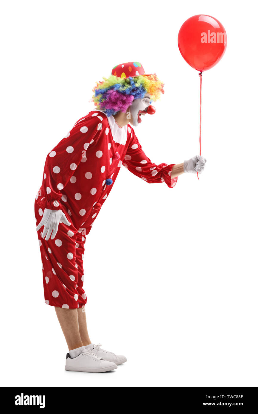 Full length profile shot of a clown holding a red balloon isolated on ...