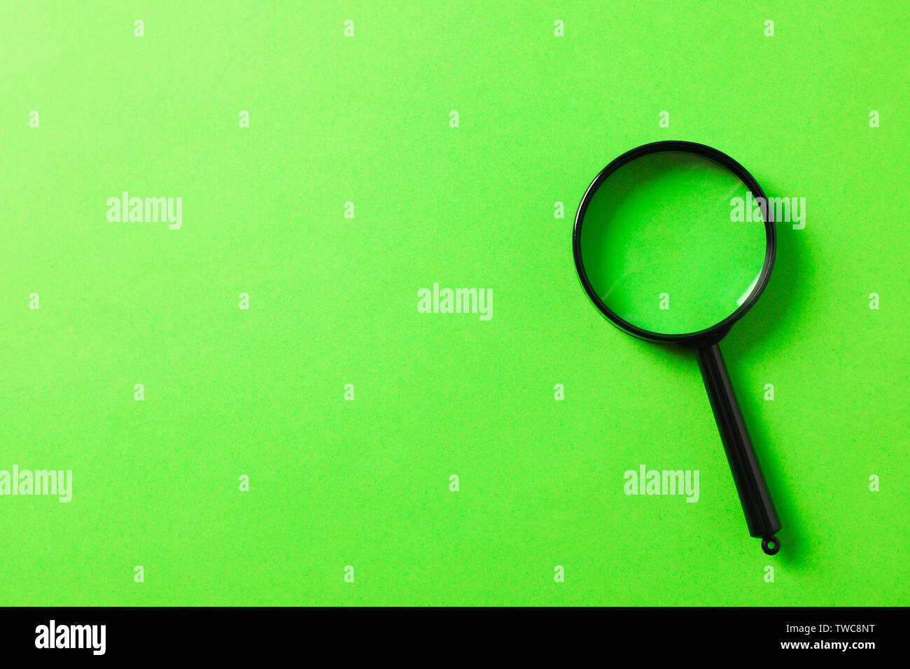 Magnifier on green background, space for text Stock Photo - Alamy