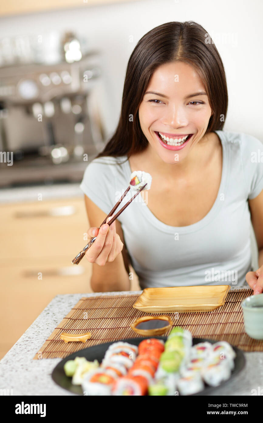 Sushi eating young asian mixed race beautiful woman. Healthy lifestyle ...