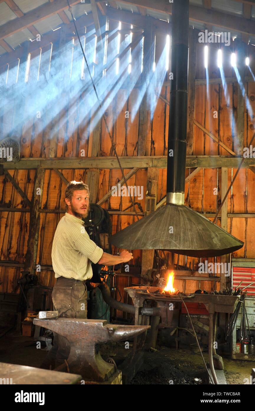 Light rays passing through wooden siding of blacksmith workshop, rural ...