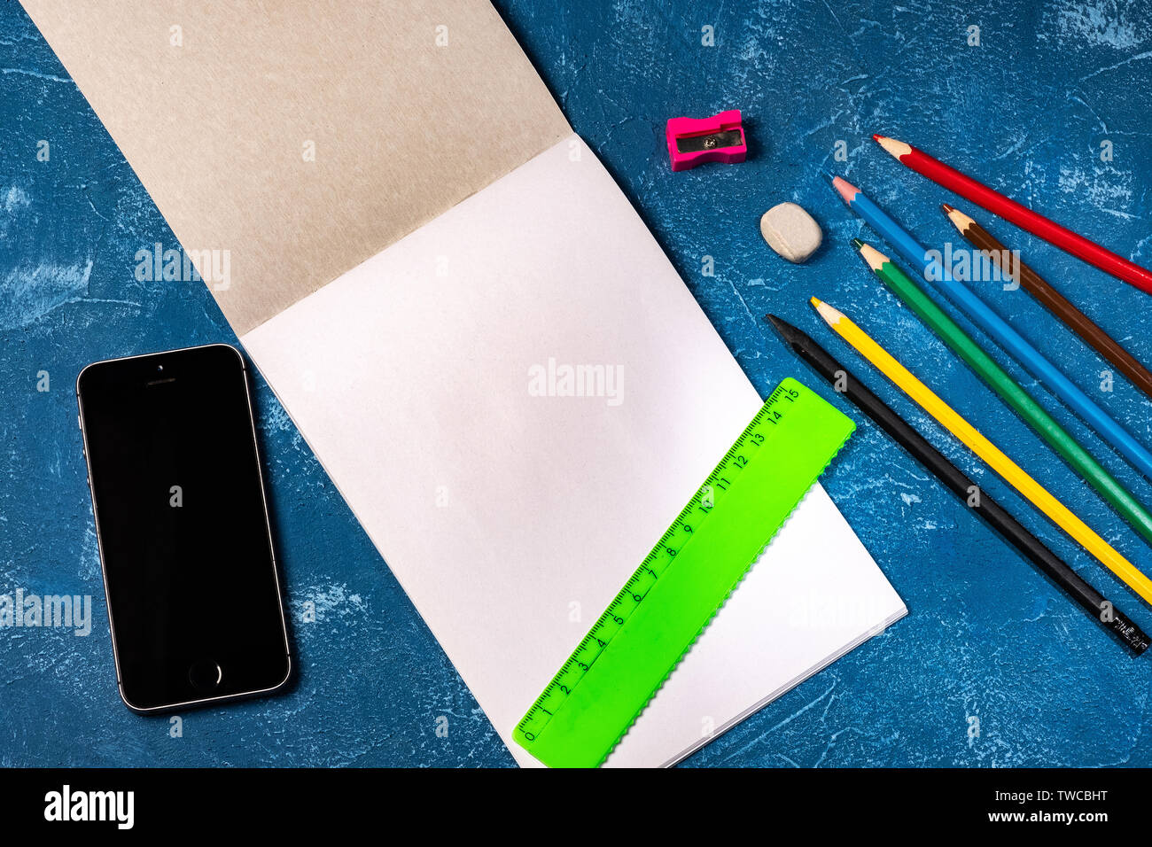 drawing pad and colored pencils on blue background Stock Photo - Alamy