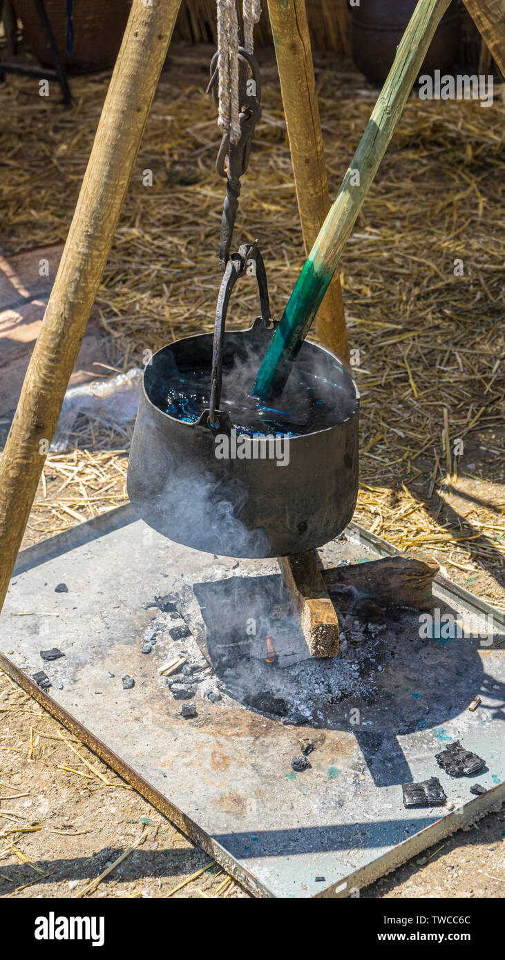 colorful handmade dyeing of fabrics and wool in a cauldron with colored ...
