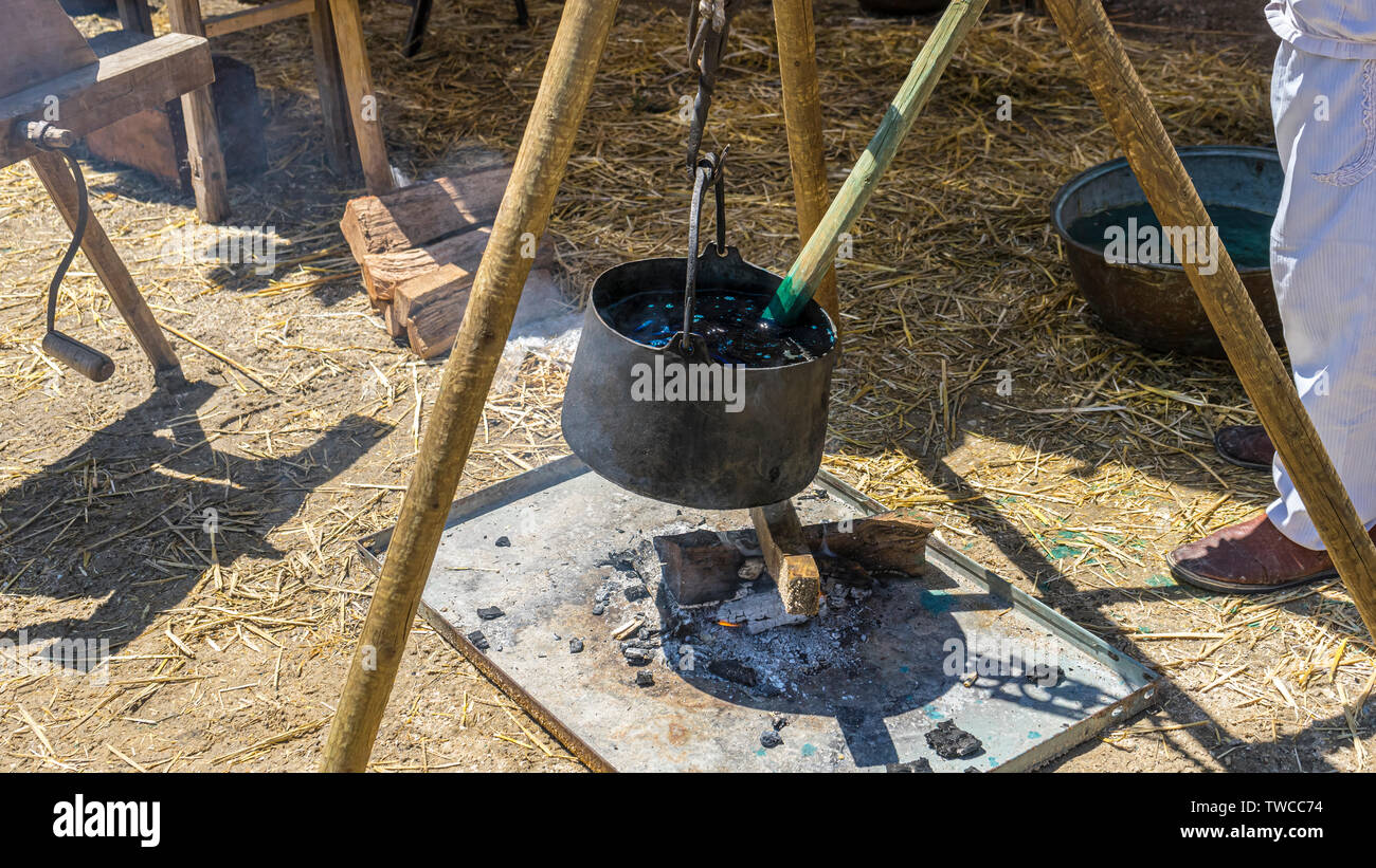 handmade dyeing of fabrics and wool in a cauldron with colored dyes in ...