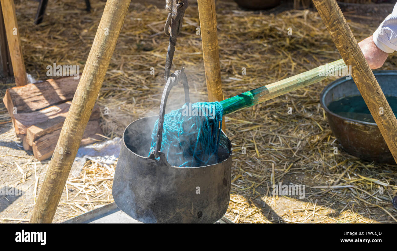 handmade dyeing of fabrics and wool in a cauldron with colored dyes in ...