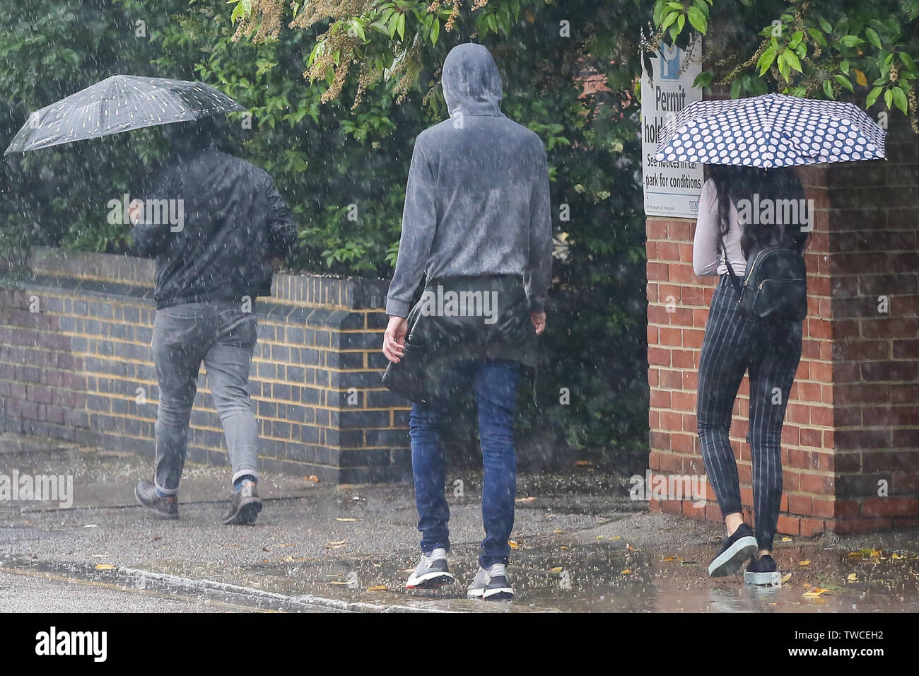 People shelter from the rain beneath umbrellas during the heavy ...