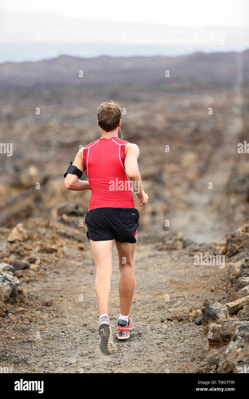 Trail runner man running cross-country run training outside for ...