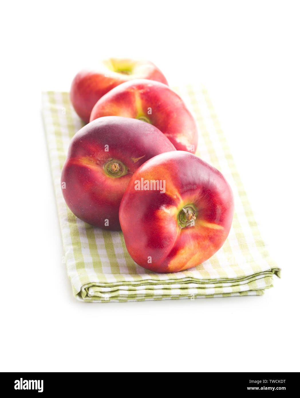 Ripe flat nectarines on checkered napkin isolated on white background ...