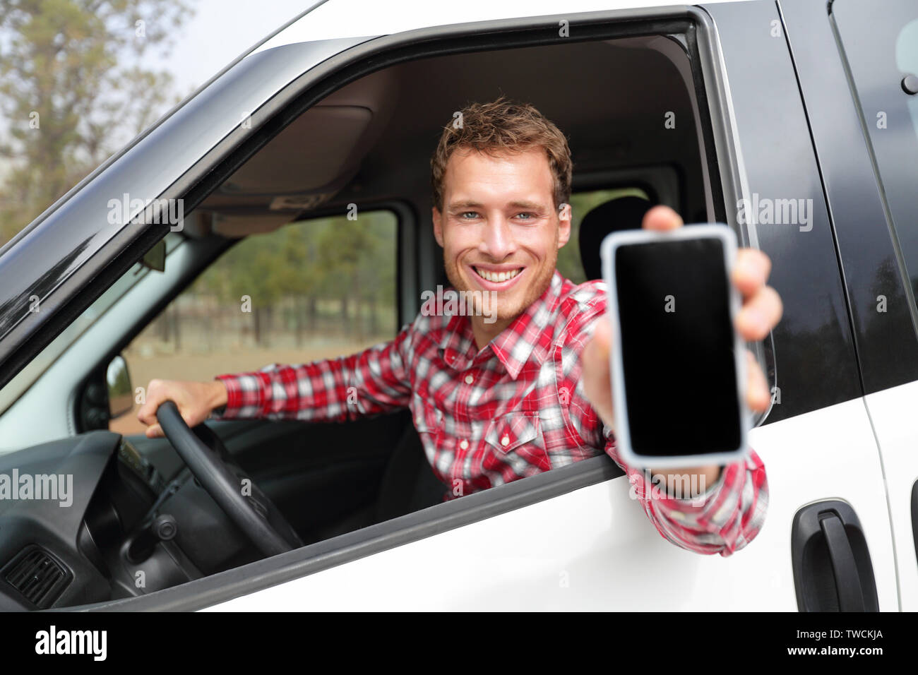 Smartphone man in car driving showing smart phone display smiling happy ...