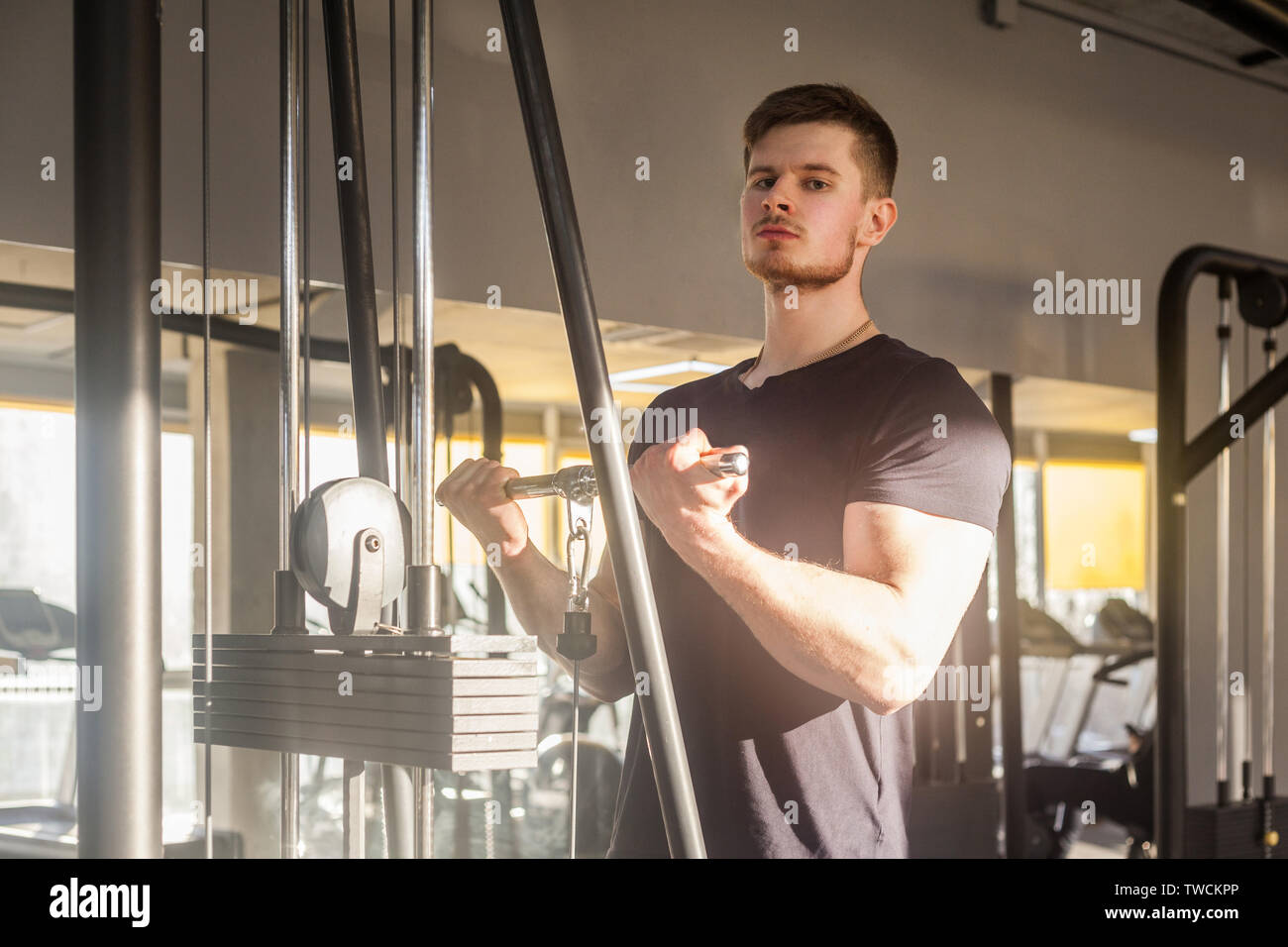Closeup portrait of young adult sport athlete man training at gym alone ...