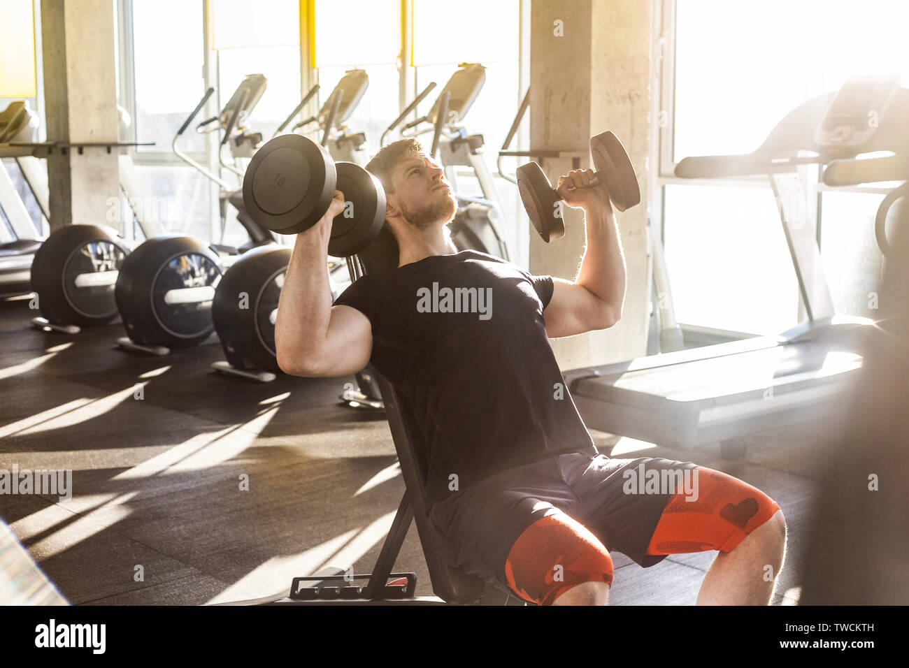 Side view portrait of young adult sport man training at gym alone ...