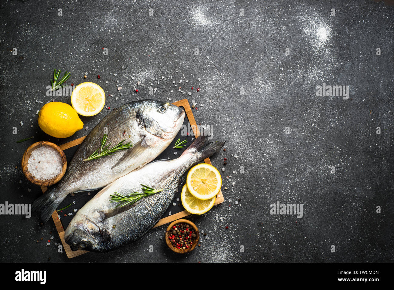 Raw dorado fish on black background Stock Photo - Alamy