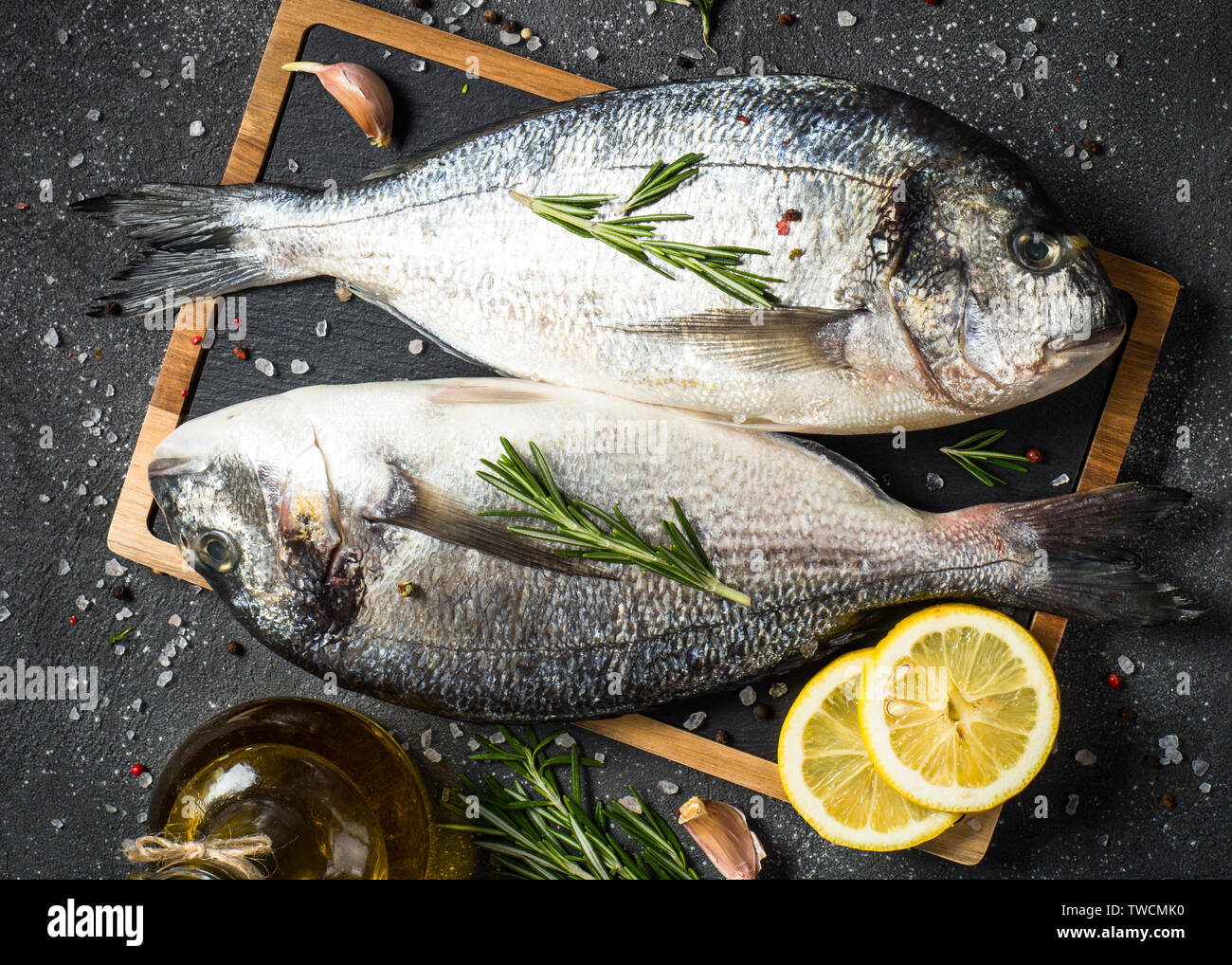 Raw dorado fish on black Stock Photo - Alamy