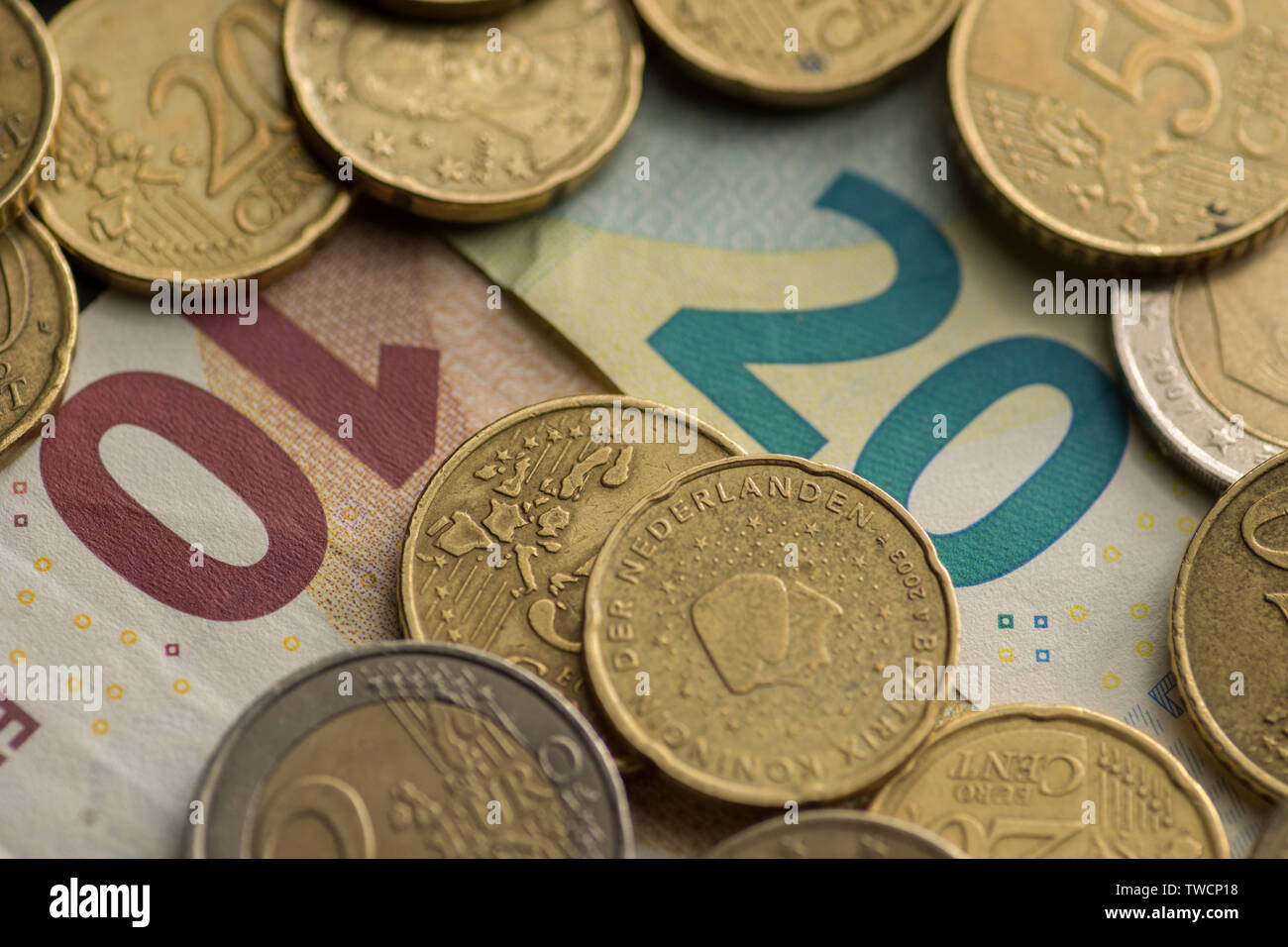 Some euro coins with a euro banknotes background Stock Photo - Alamy