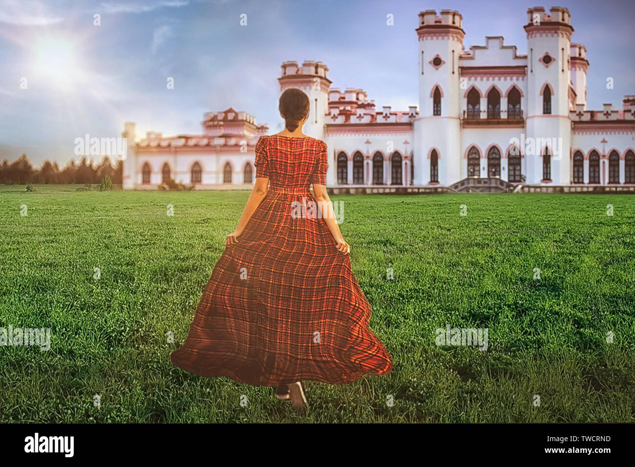 Young beautiful princess in a long red dress on the castle background ...