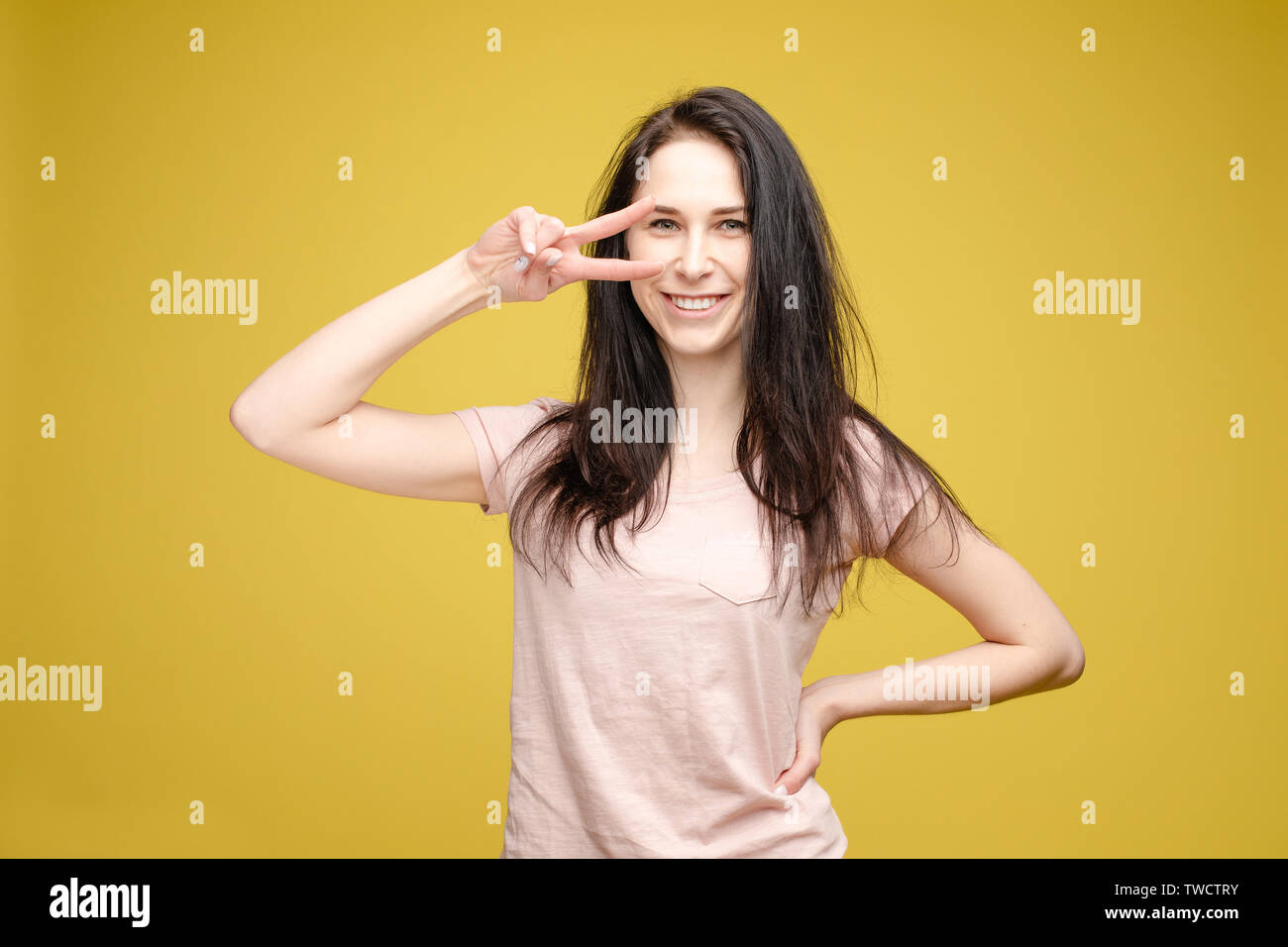 Pretty girl in white top with peace sign Stock Photo - Alamy