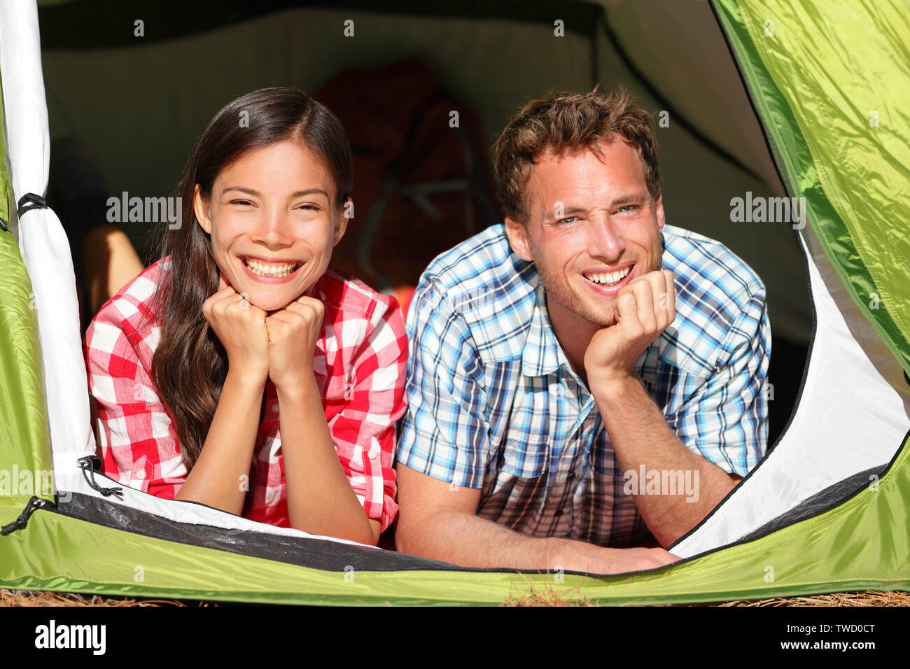 Happy romantic couple camping in tent looking in forest. Campers ...