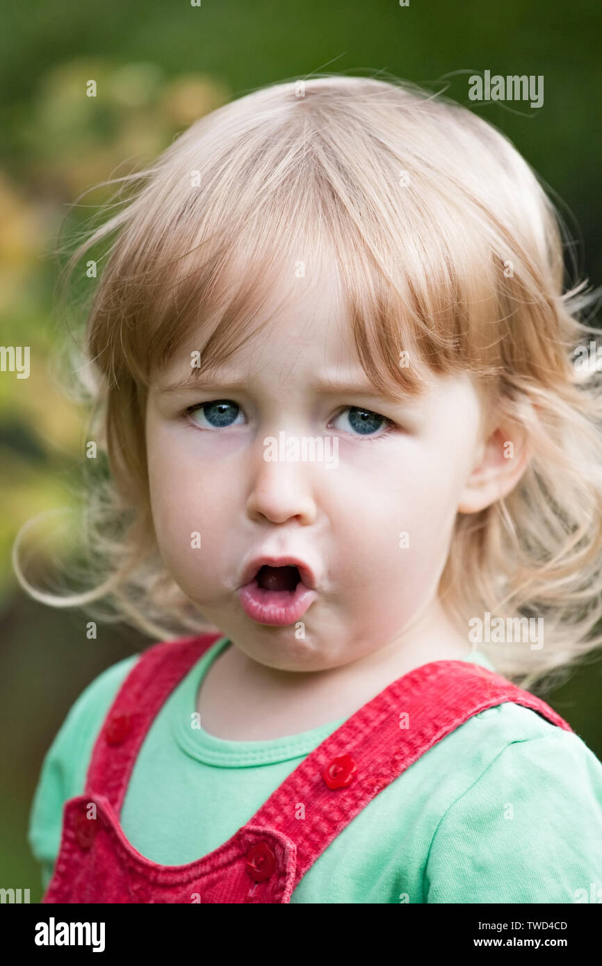 closeup face portrait of chewing cute two years old blonde white girl ...