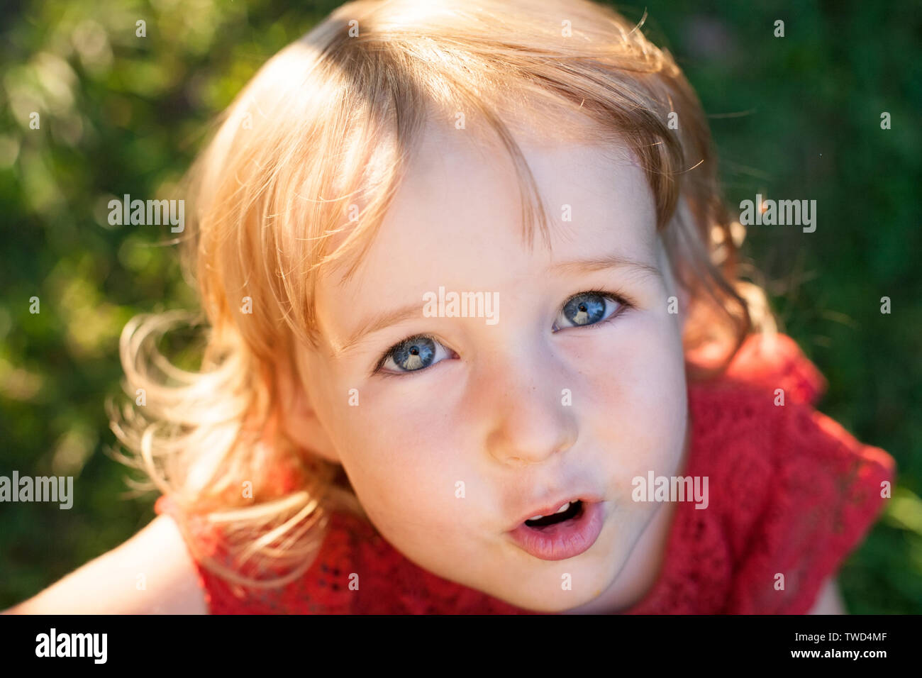 closeup top view of cute little caucasian gilr face on summer outdoor ...