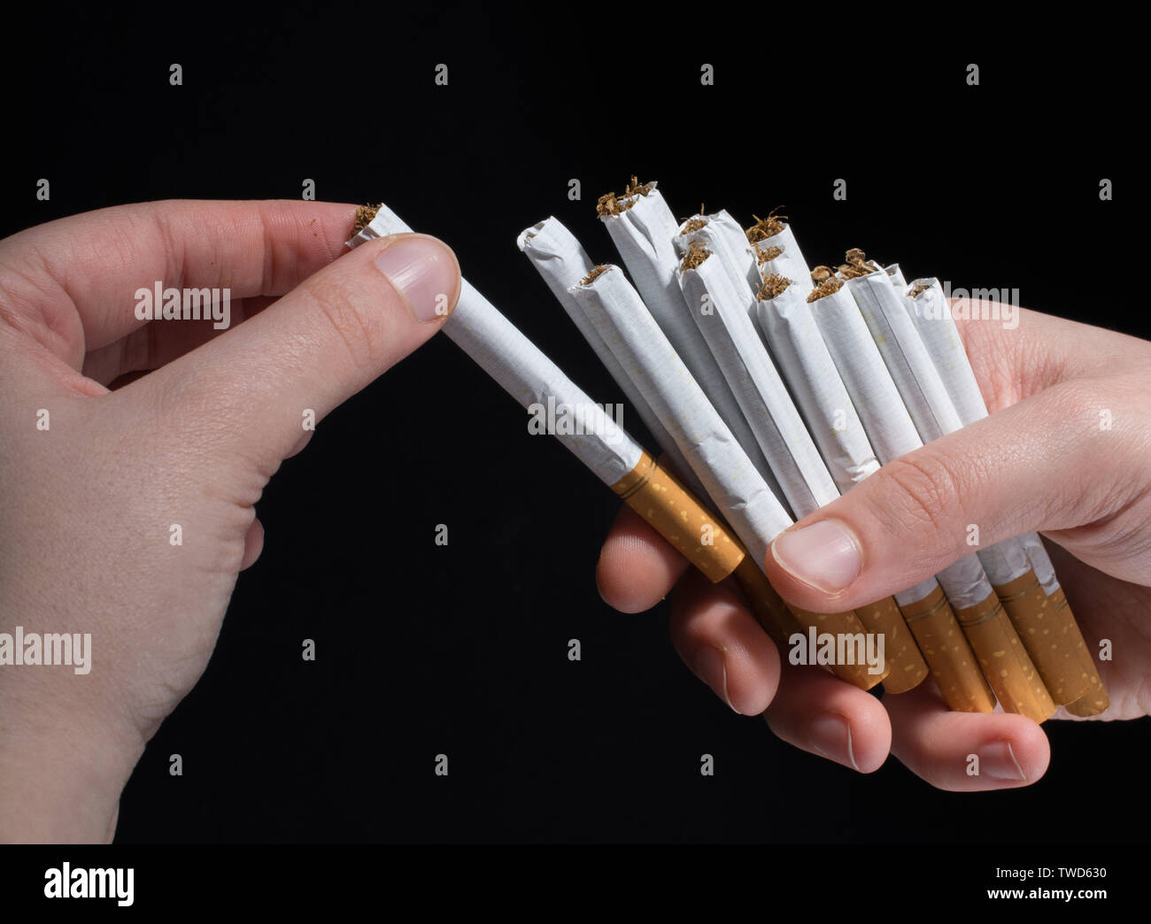 Hand is giving out bundle of cigarettes on black background Stock Photo ...