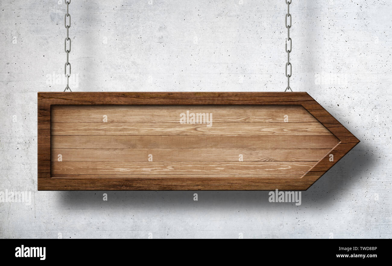 Arrow shaped sign hanging on chains with concrete wall background Stock ...