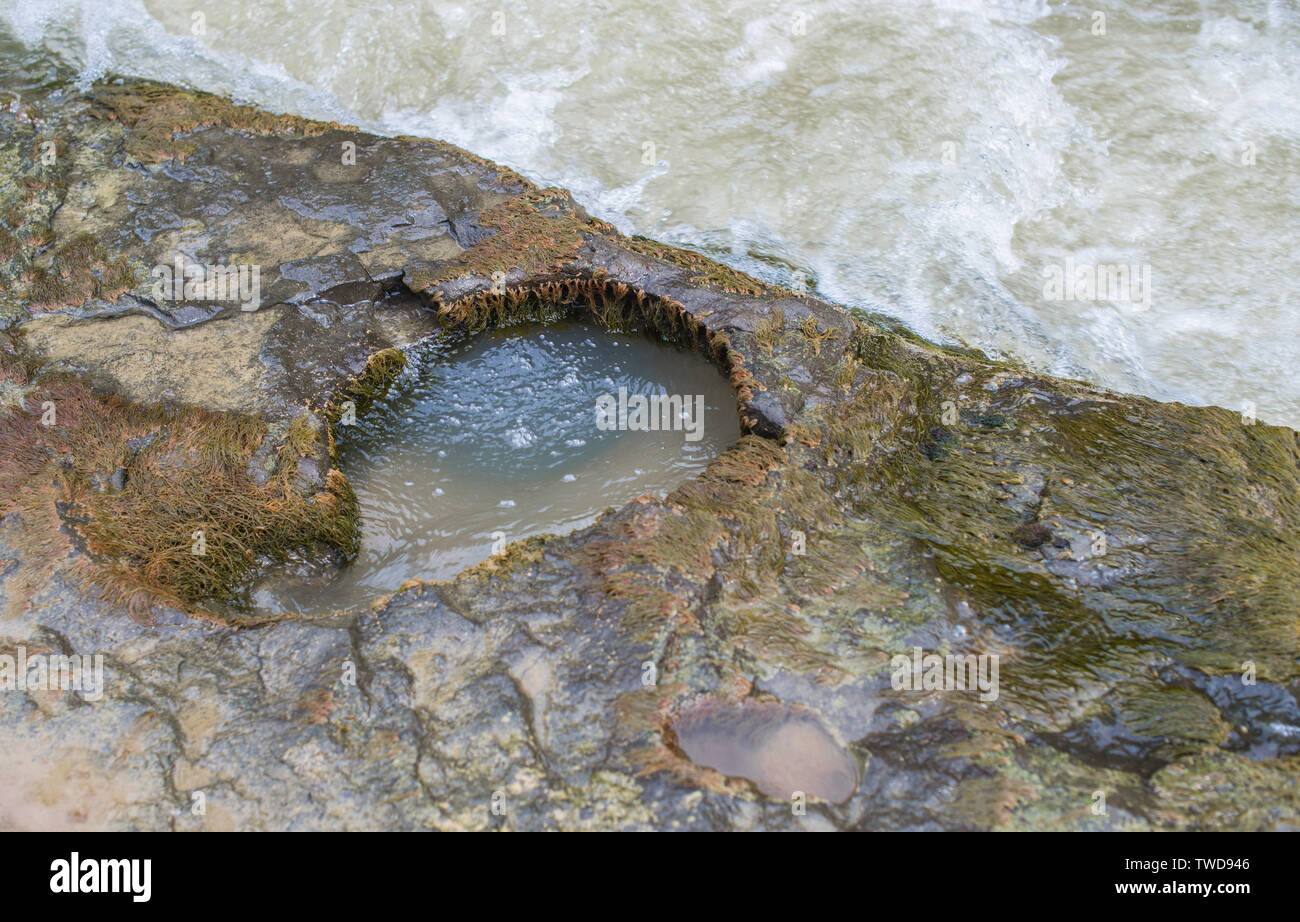 A small cave in the river carved the rocky shore Stock Photo - Alamy