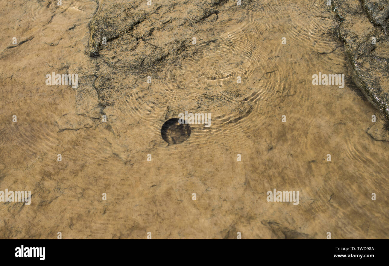Smooth round hole is drilled in the rocks under the water Stock Photo ...