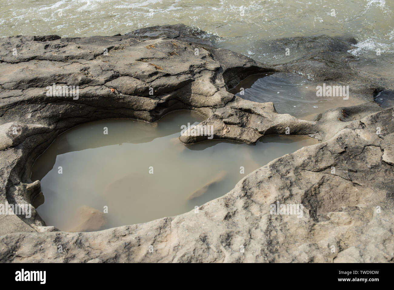The holes filled with water in the rock formation Stock Photo - Alamy