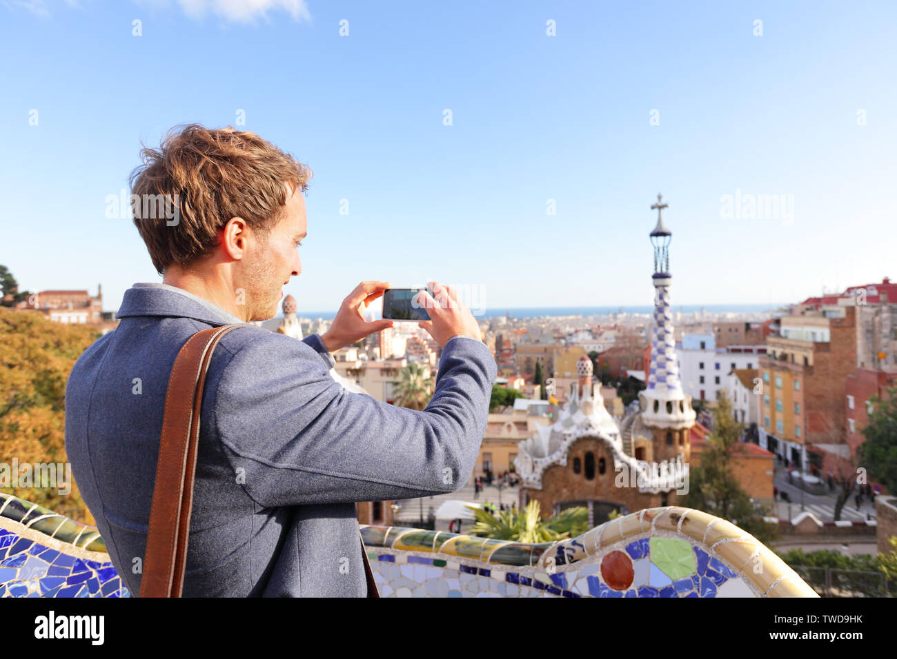 Tourist man taking photo in with smartphone in Park Guell, Barcelona ...