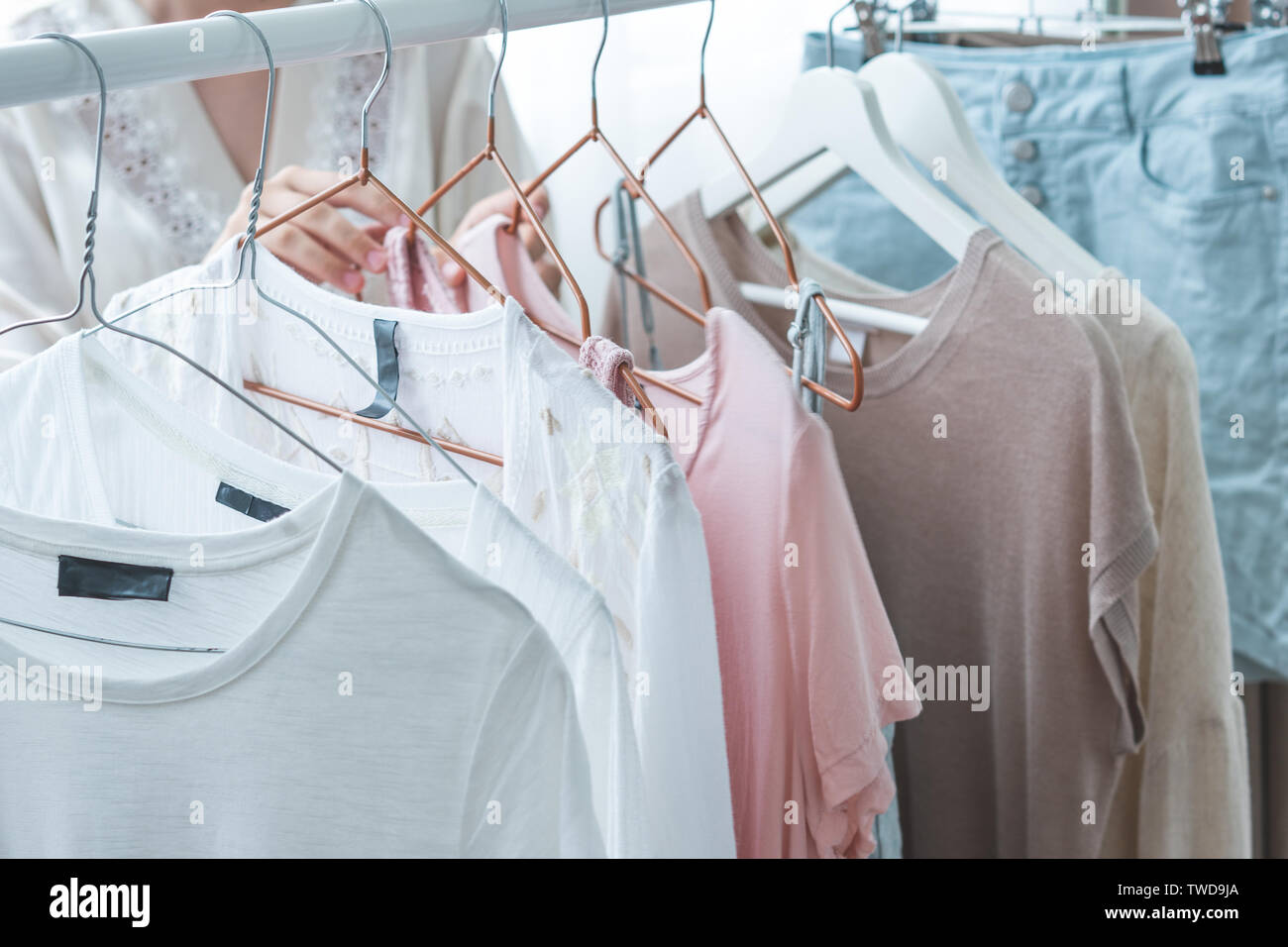 clothing, fashion, style and people concept - woman choosing clothes at ...