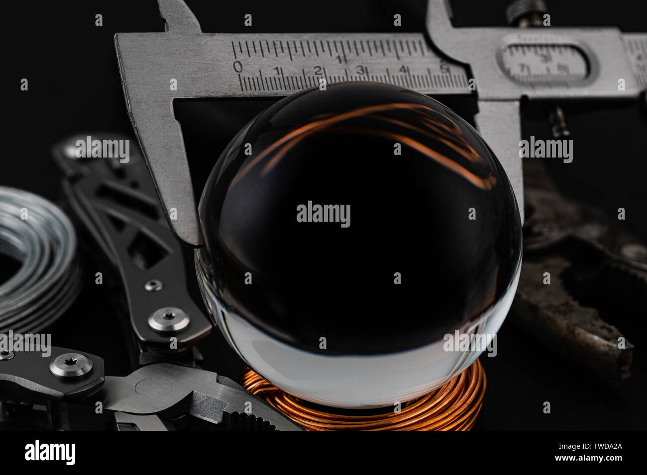 A Glass Sphere being measured with a caliper with tools around it on ...