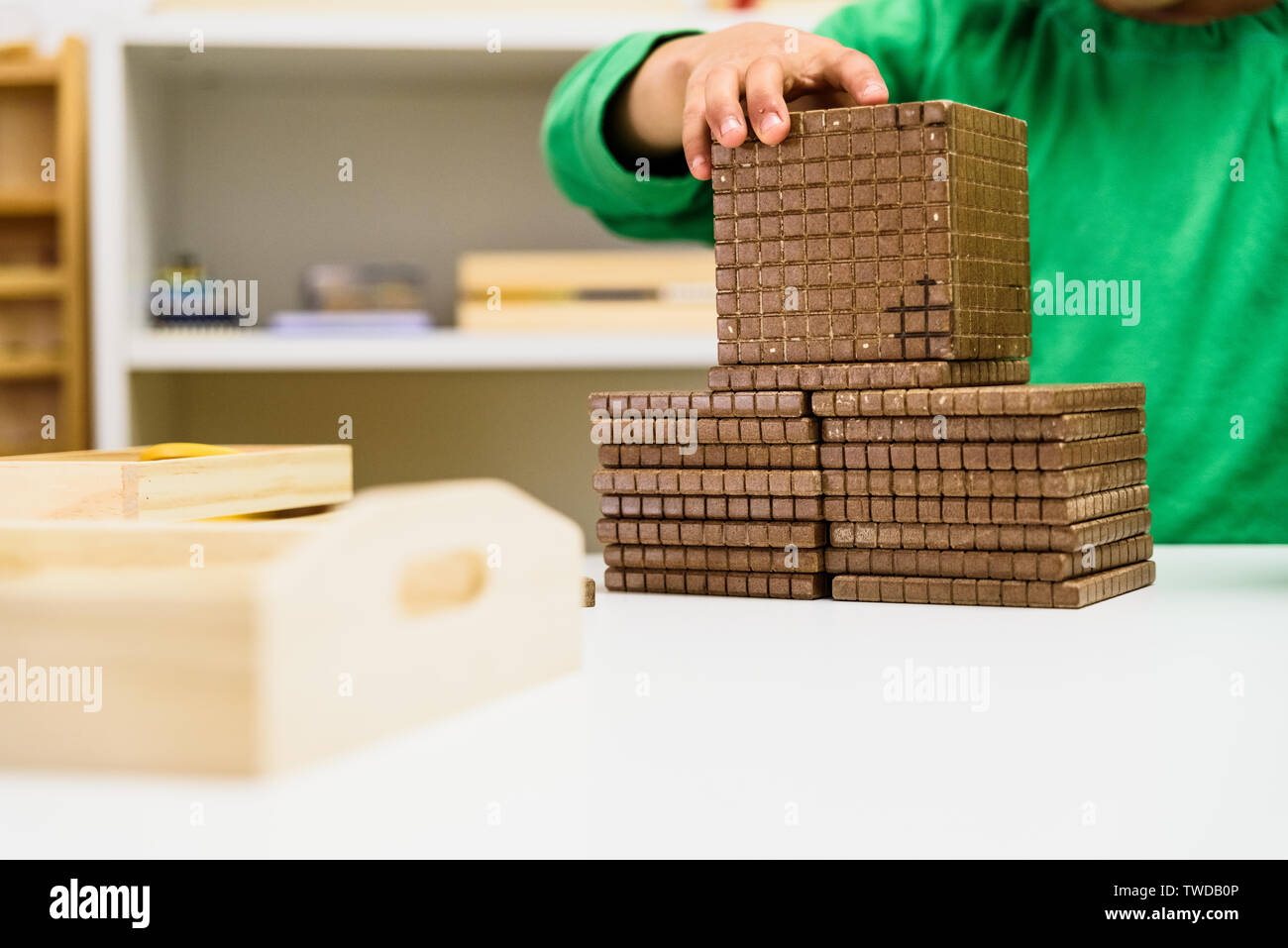 Child placing some blocks to count numbers is his house, concept of ...
