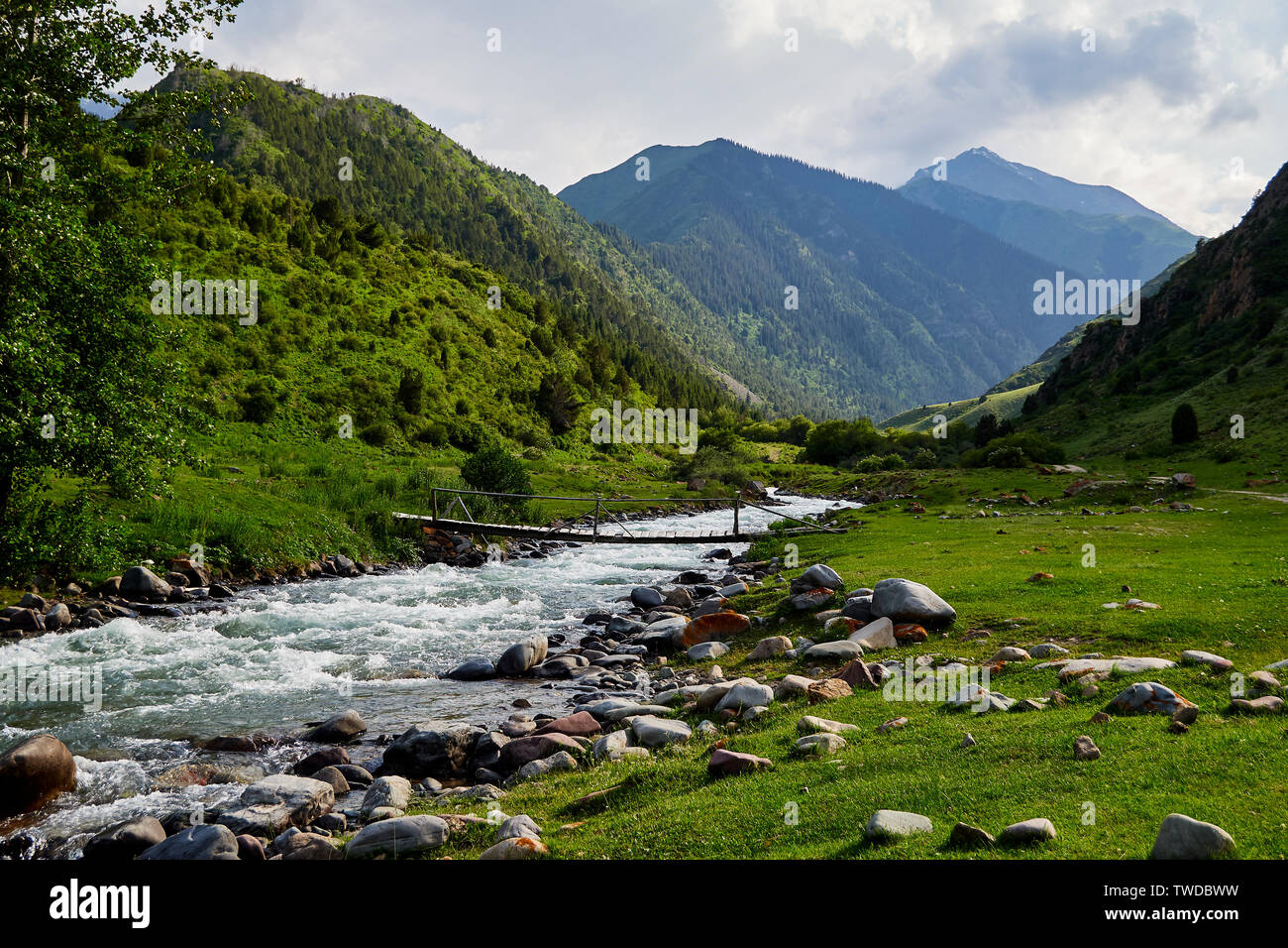 mountain river flows from the gorge with a small dilapidated wooden ...