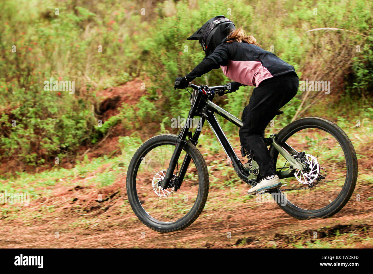 a female cyclist riding fast her downhill bike at a race, negative ...