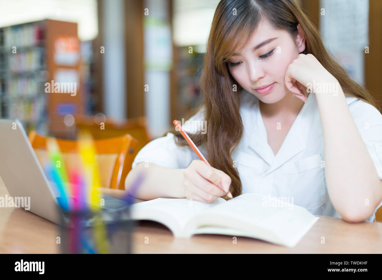 young beautiful asian girl university student with laptop in library ...