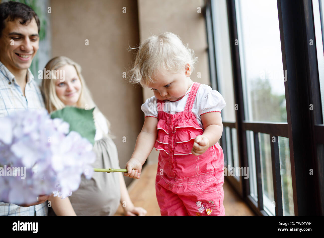 young parents admire one year old daughter Stock Photo - Alamy