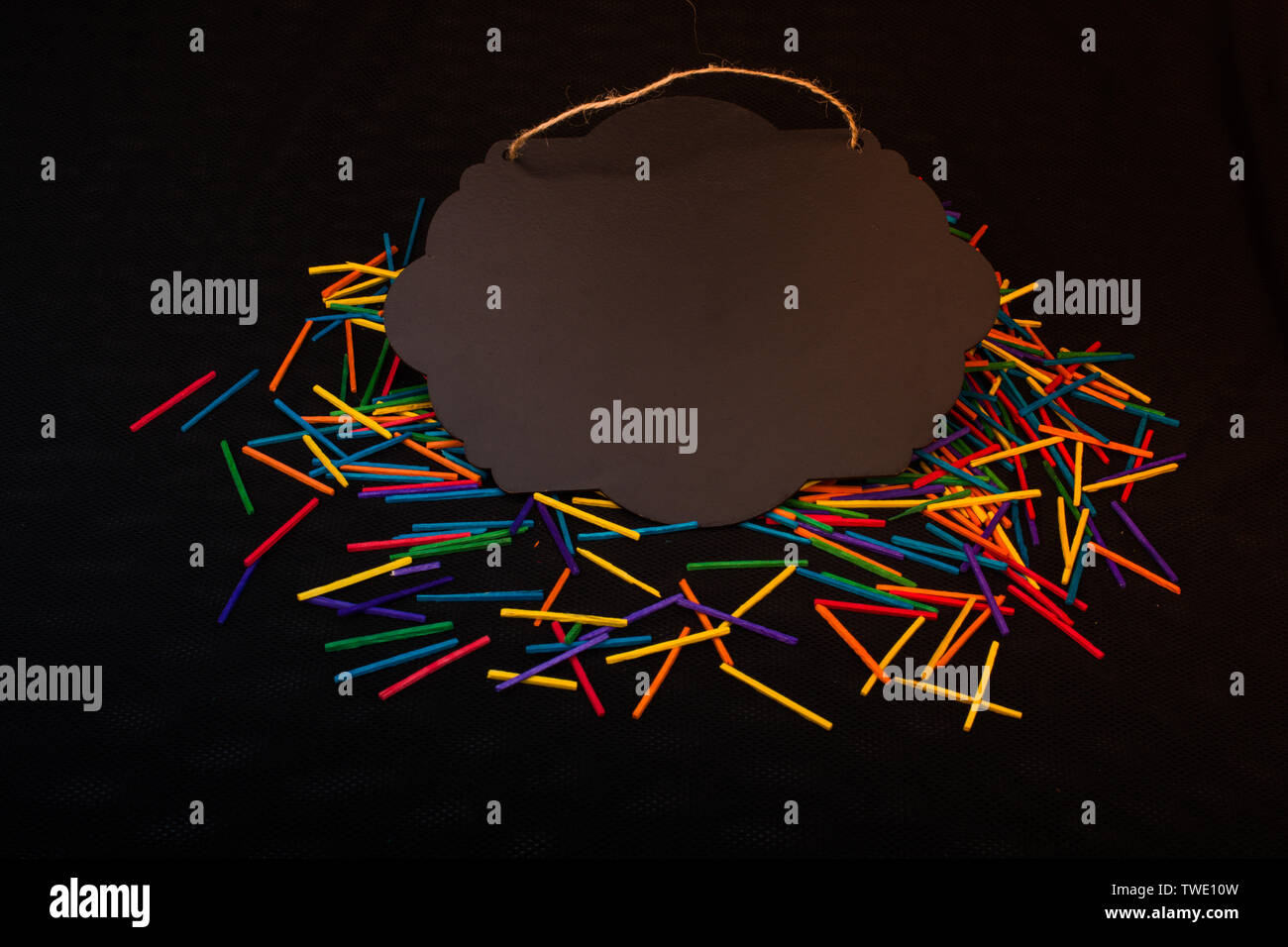 Black speech bubble shaped notice board on colorful sticks on black ...