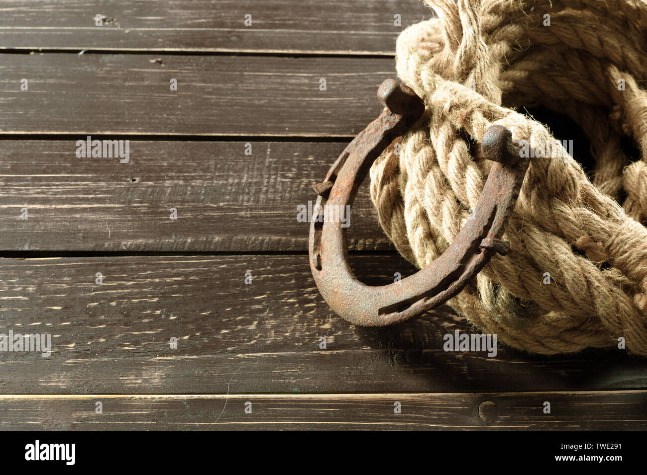 Old horseshoe and rope on wooden boards Stock Photo - Alamy