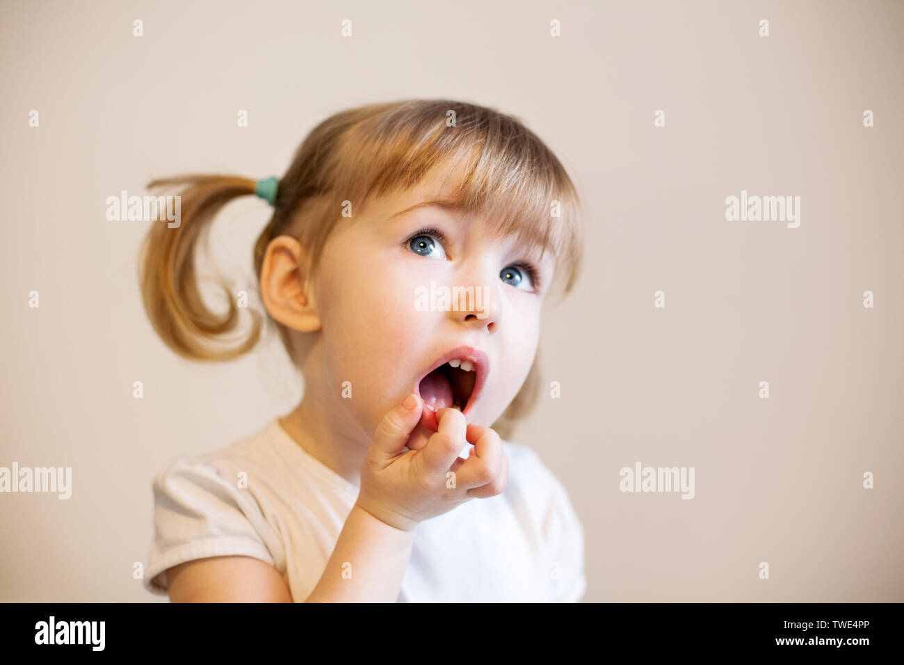 funny two years old girl with two cute pigtails, quiff and open mouth ...