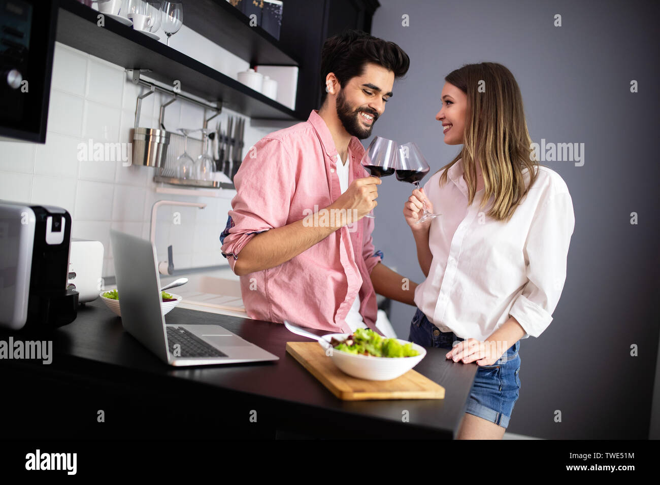 oung couple is talking and smiling while cooking healthy food in ...