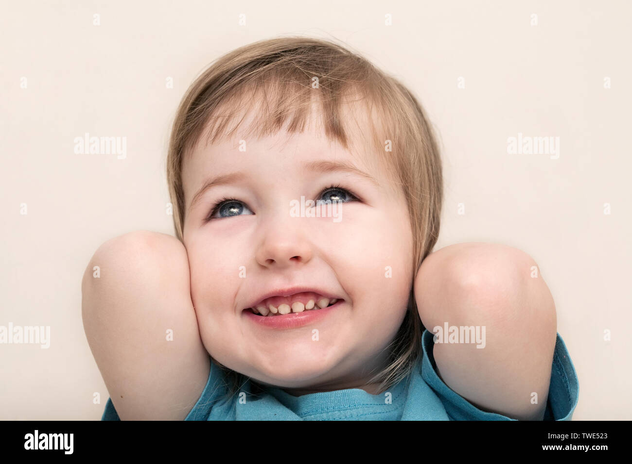 funny admiration emotional white child girl face closeup on beige wall ...