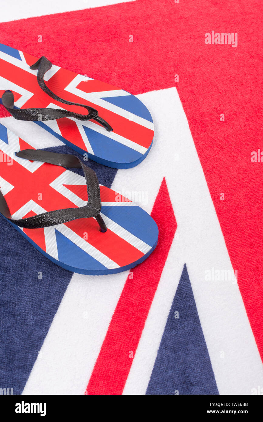 Union Jack beach flip-flops and Union Jack beach towel. Metaphor for ...