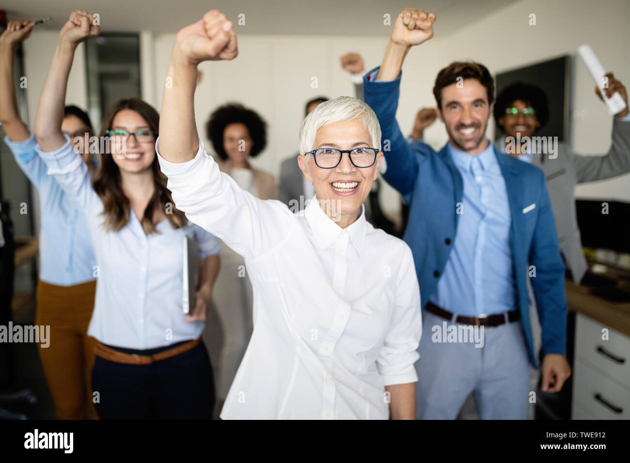 Happy business people celebrating success at company Stock Photo - Alamy