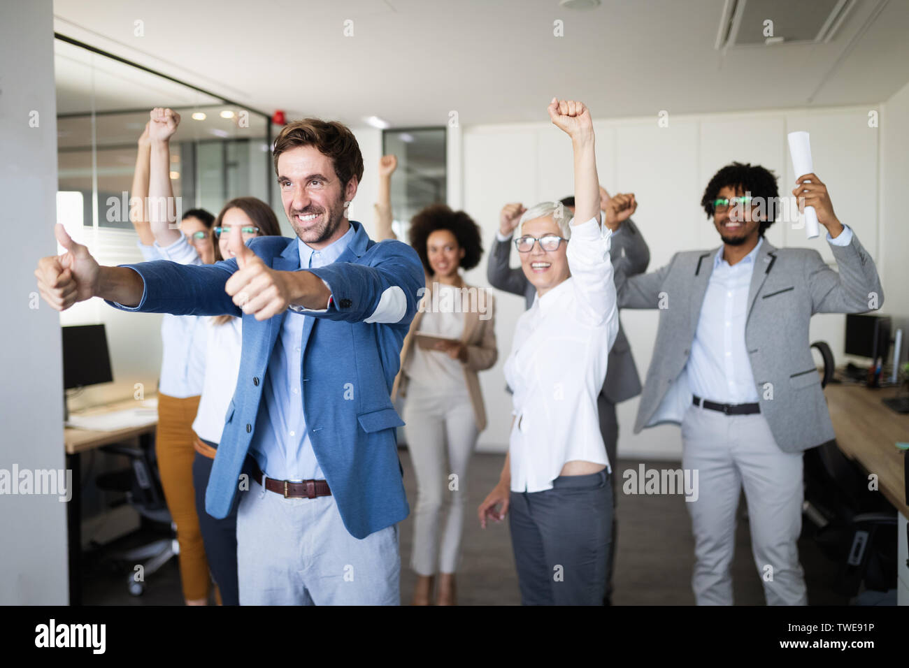 Successful company with happy workers in office Stock Photo - Alamy