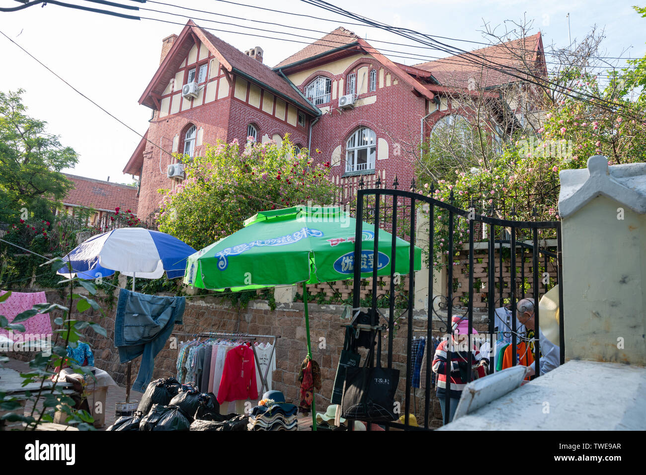 Qingdao, China. 28th May, 2019. A woman sells clothes outside a German ...